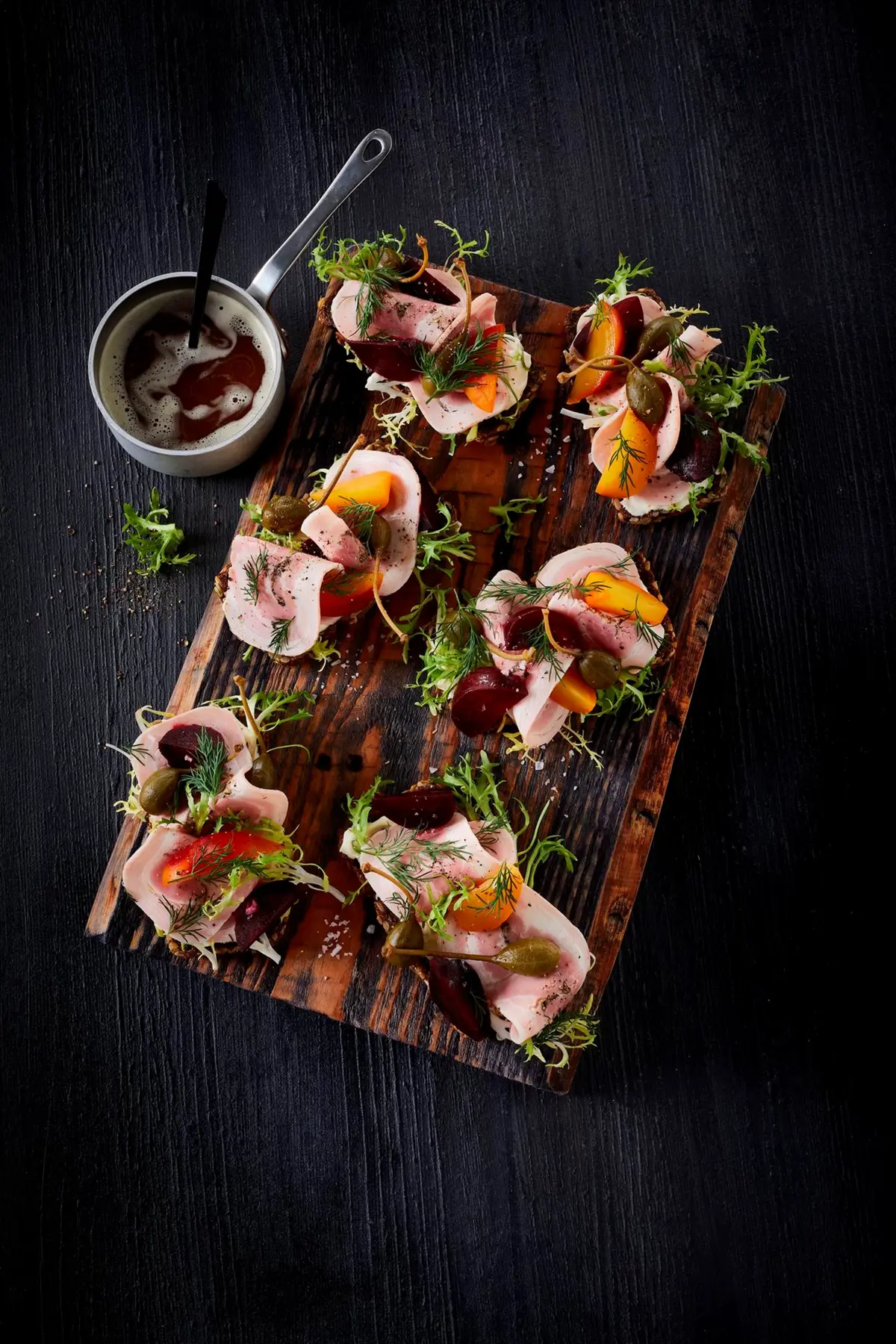 Smørrebrød med rullepølse, rødbeder og gulbeder, kapers og brunet smør ...